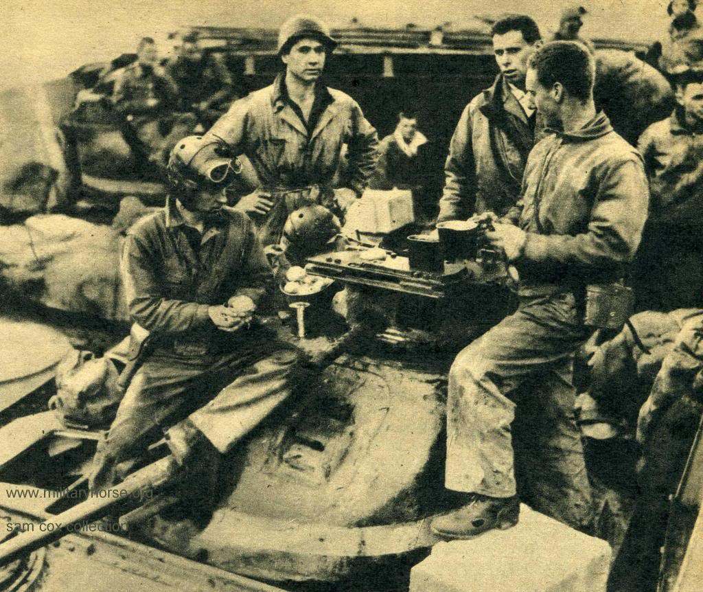 Photo of a tank officer standing next to tanks loaded on a ship WWII ...